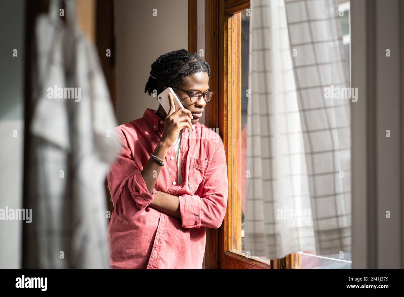 Sad upset African man having difficult conversation on phone, standing ...
