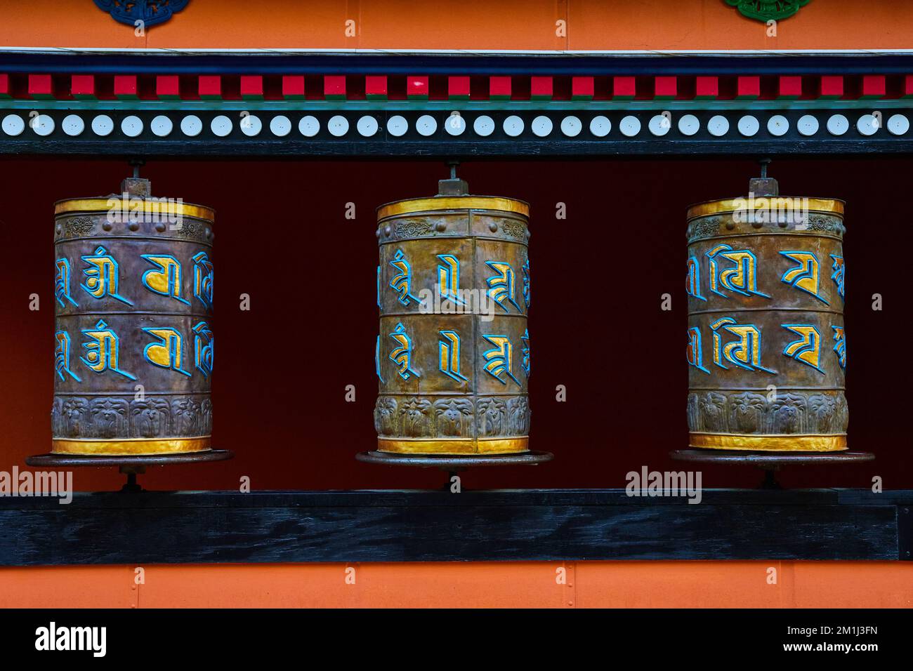 Three large prayer wheels at shrine Stock Photo - Alamy