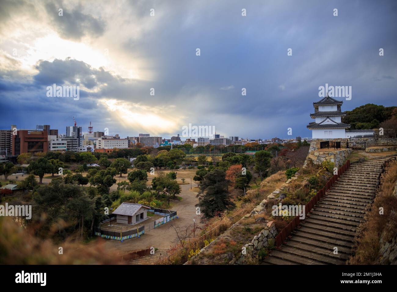 God rays break through storm clouds over Japanese castle in small city ...