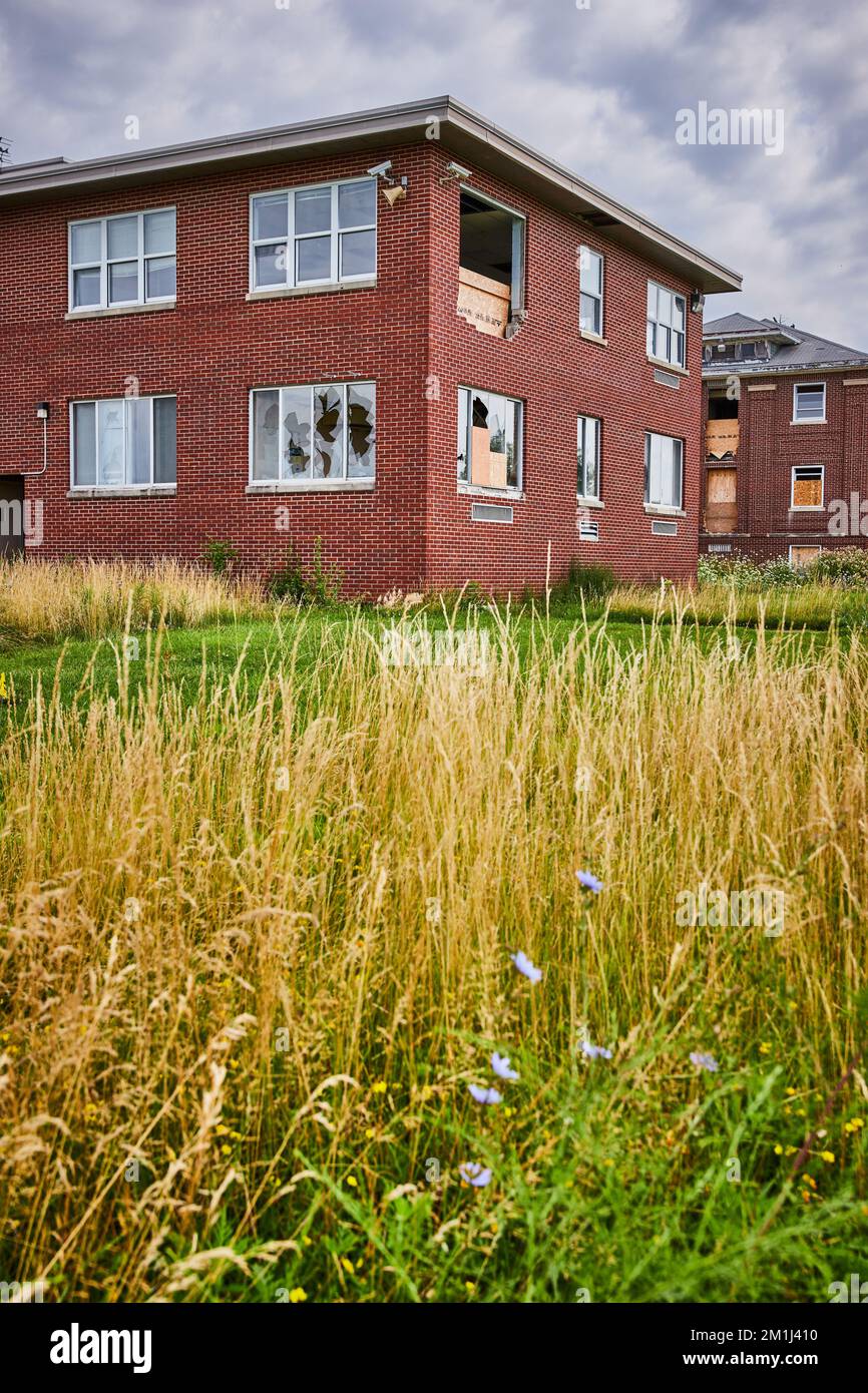 Grassy fields outside of abandoned brick buildings Stock Photo - Alamy
