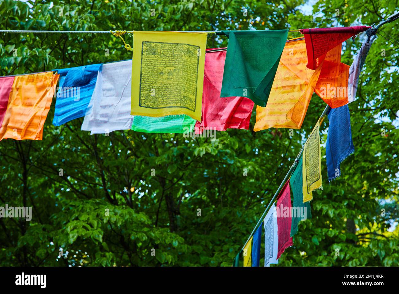 Rope covered in dozens of colorful Buddhist prayer flags Stock Photo ...