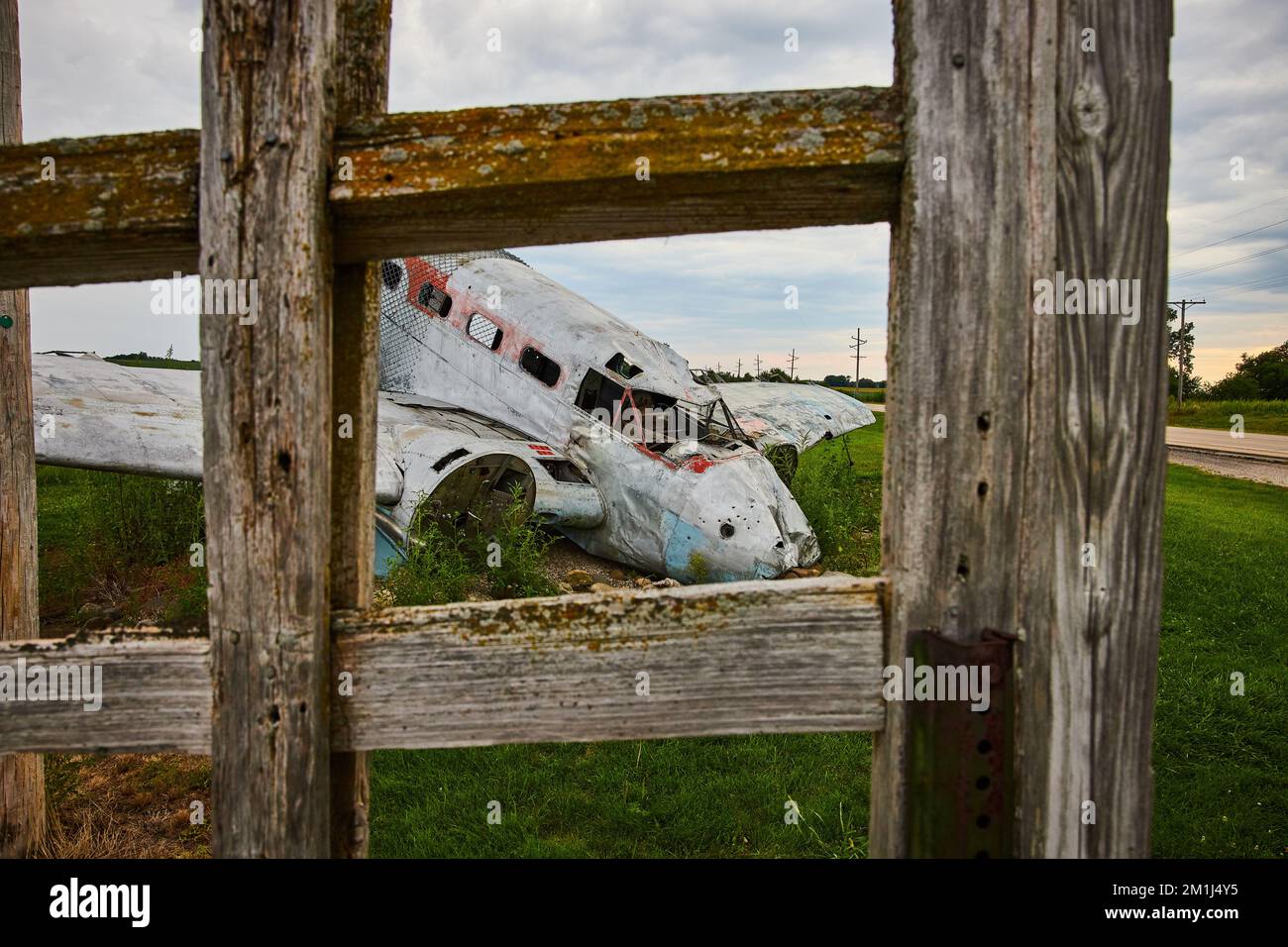 View through wood fence of crashed airplane in field Stock Photo - Alamy