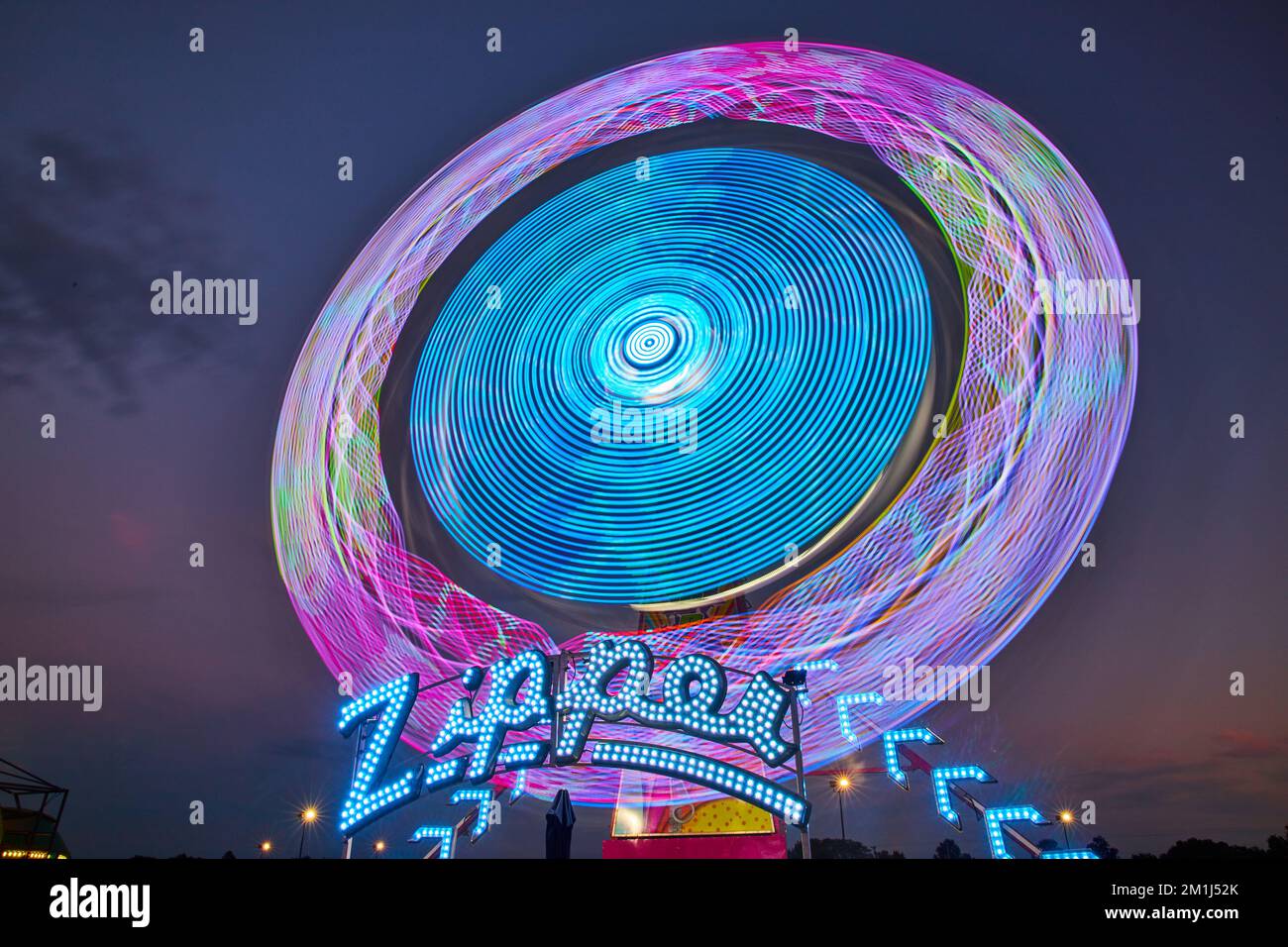 Zipper carnival ride blurred into full circle of colorful lights during ...