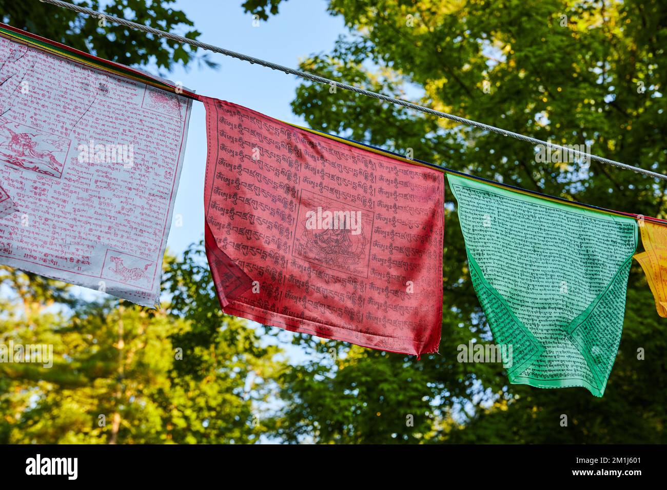 White, red, and green Tibetan Mongolian Buddhist prayer flags on rope ...