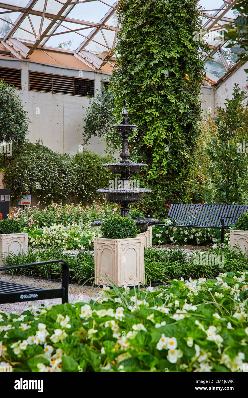 Detail of black water fountain inside botanical gardens with benches ...