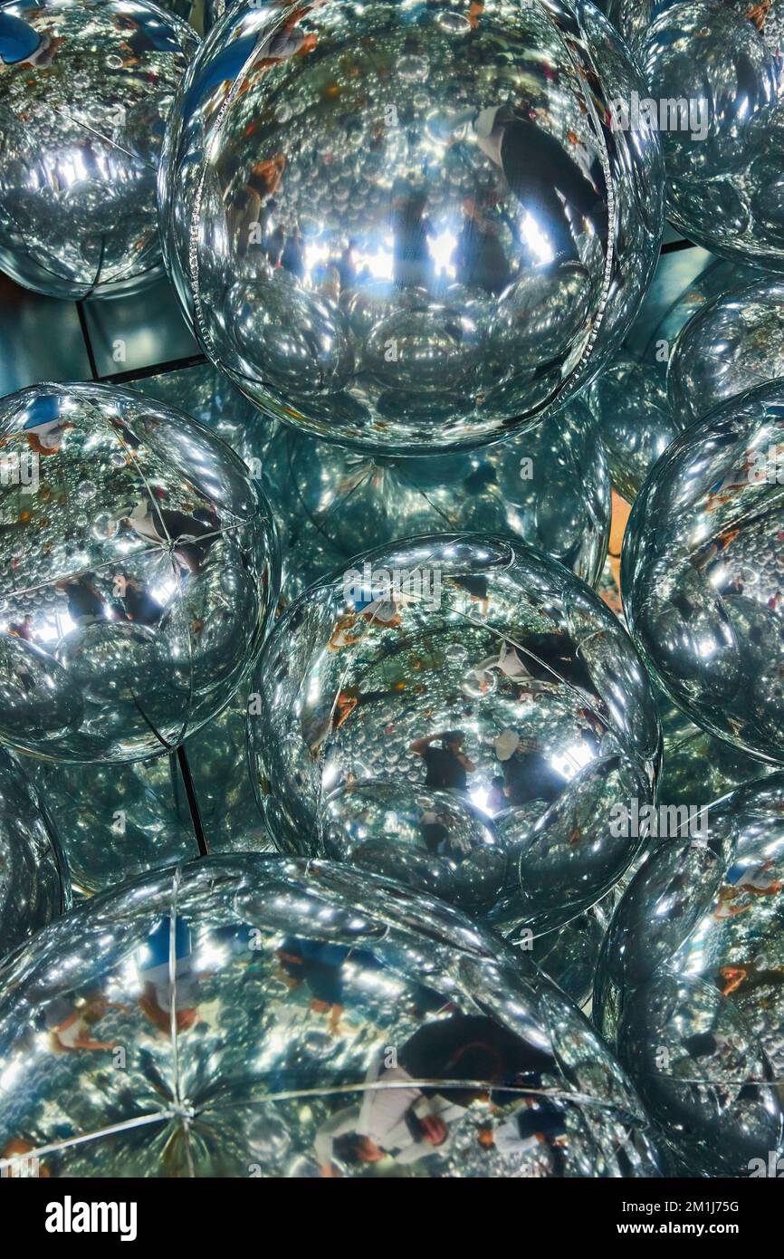 Detail of dozens of reflective mirror helium balloons showing more ...