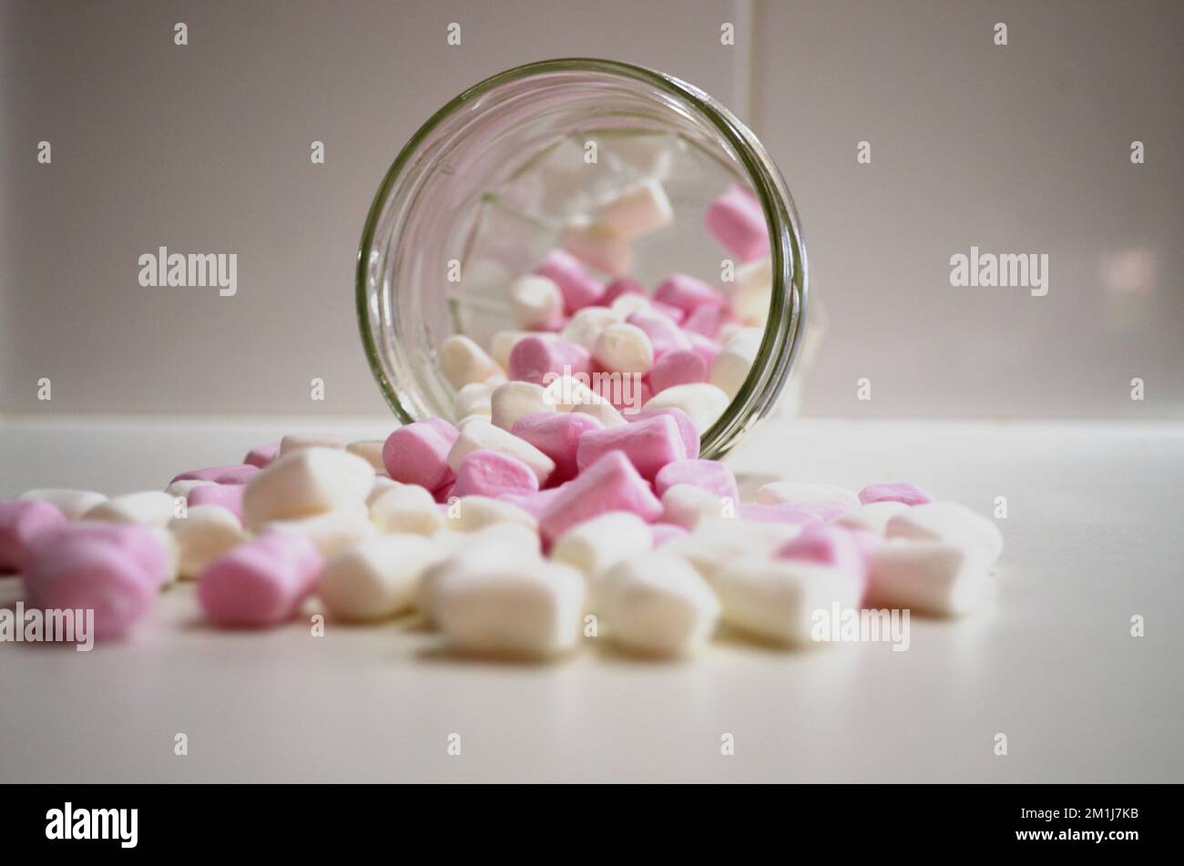 Mini, small Marshmallows poured from jar on to kitchen bench Stock ...