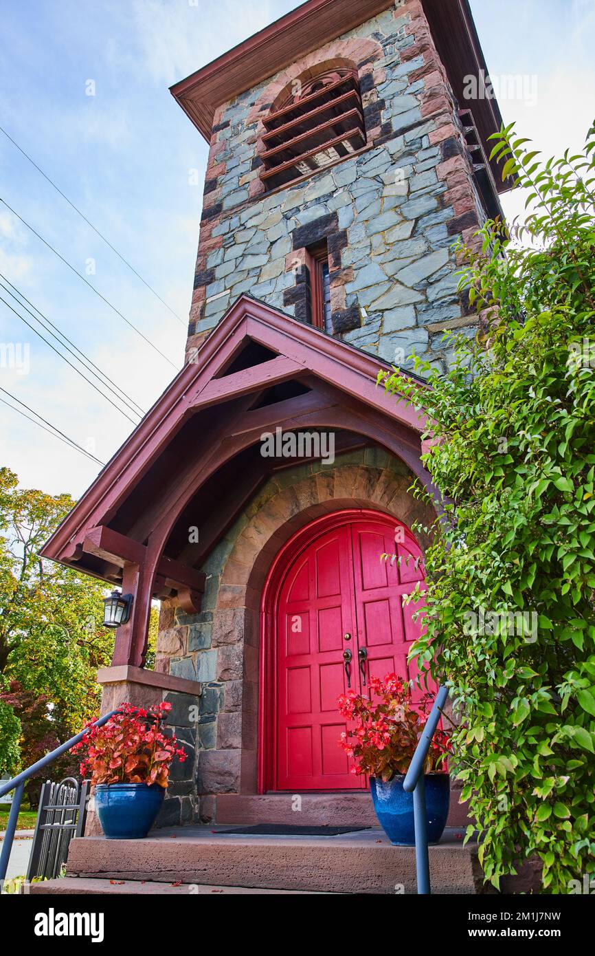 Front entrance to stone church with huge double red doors and steeple ...