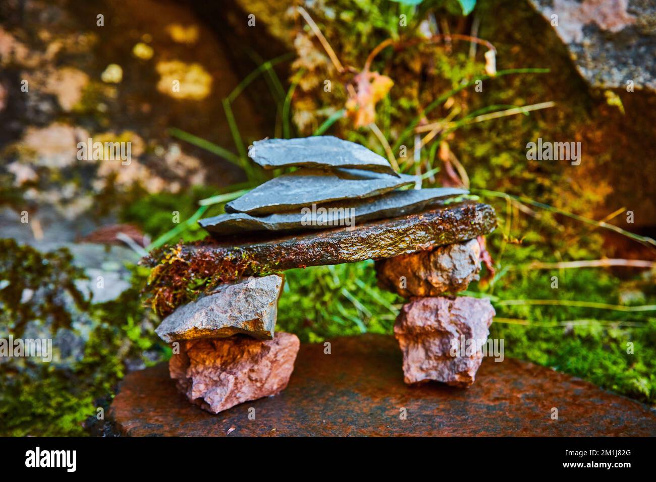 Cairn stone stack structure tiny scene against moss and lichen-covered ...