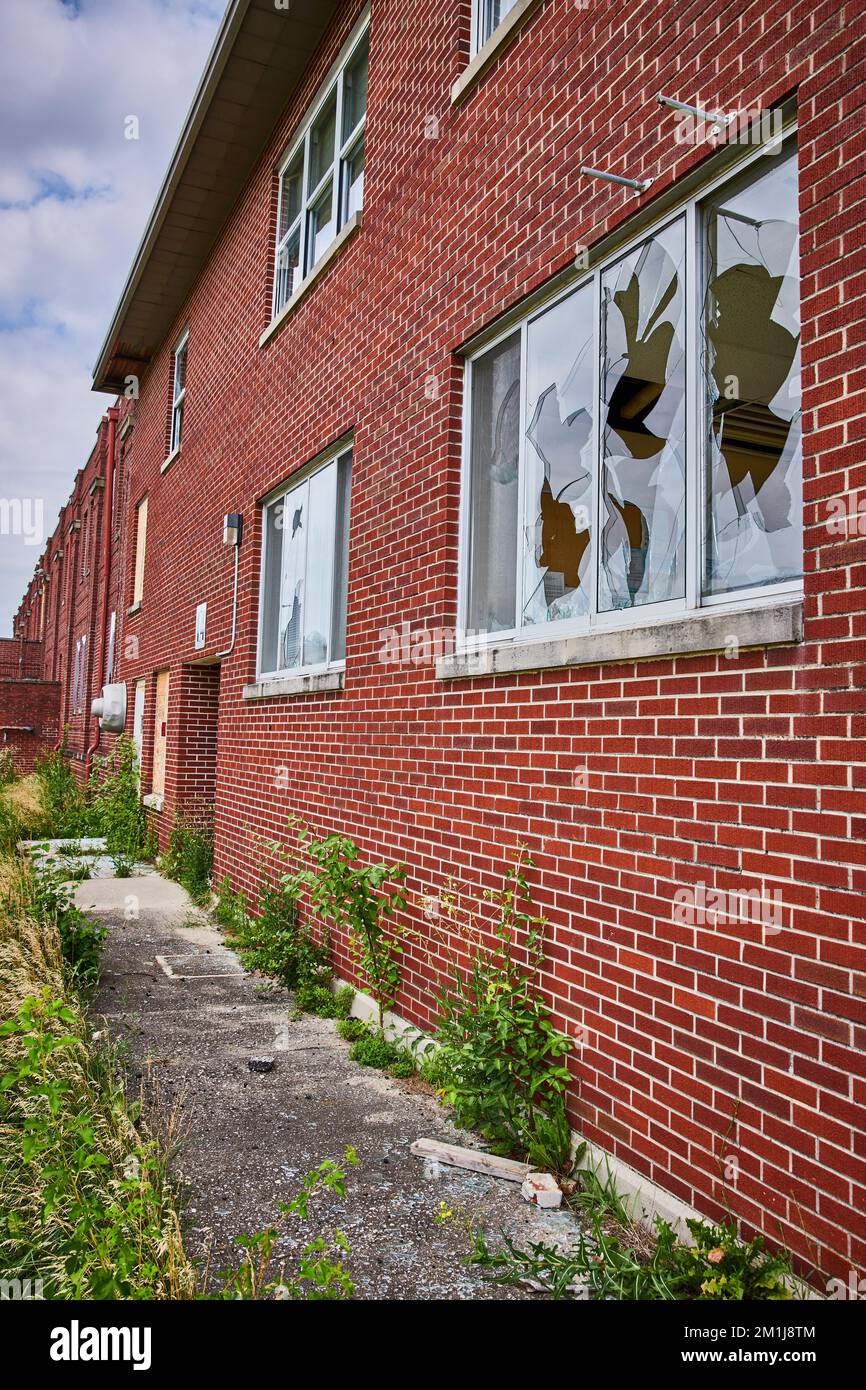 Broken windows on exterior of abandoned brick hospital in midwest ...