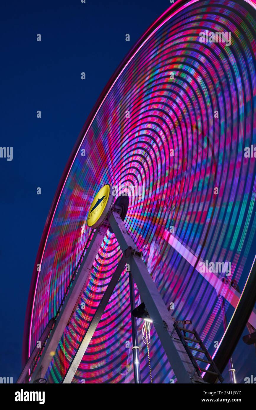 Blurred purple lights at night on ferris wheel at carnival county fair ...