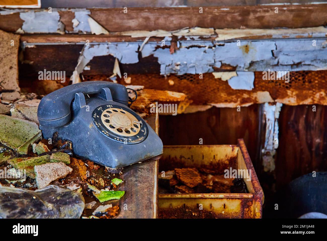 Vintage rotary phone on abandoned desk in detail with decayed wall ...