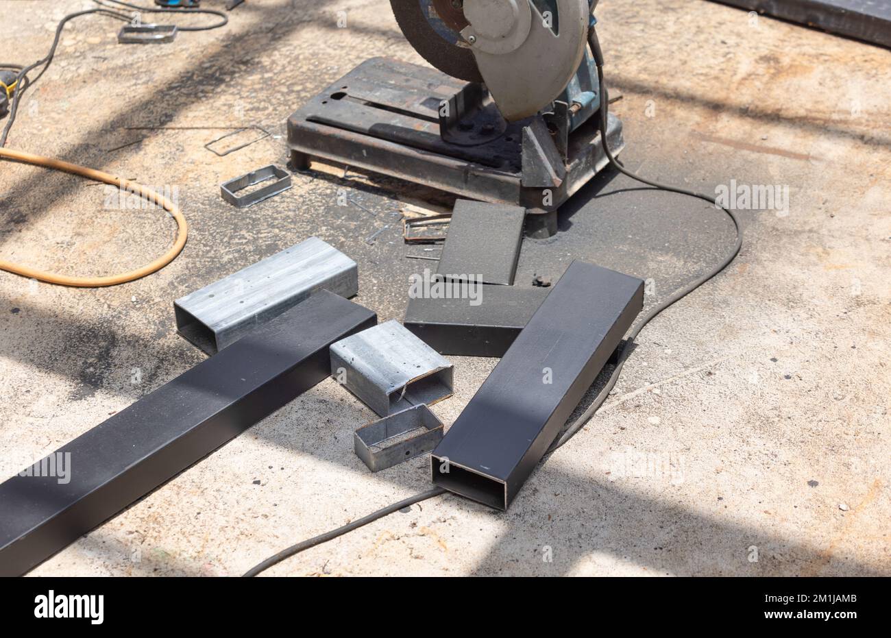 Worker cutting steel rectangular pipe in construction site Stock Photo ...
