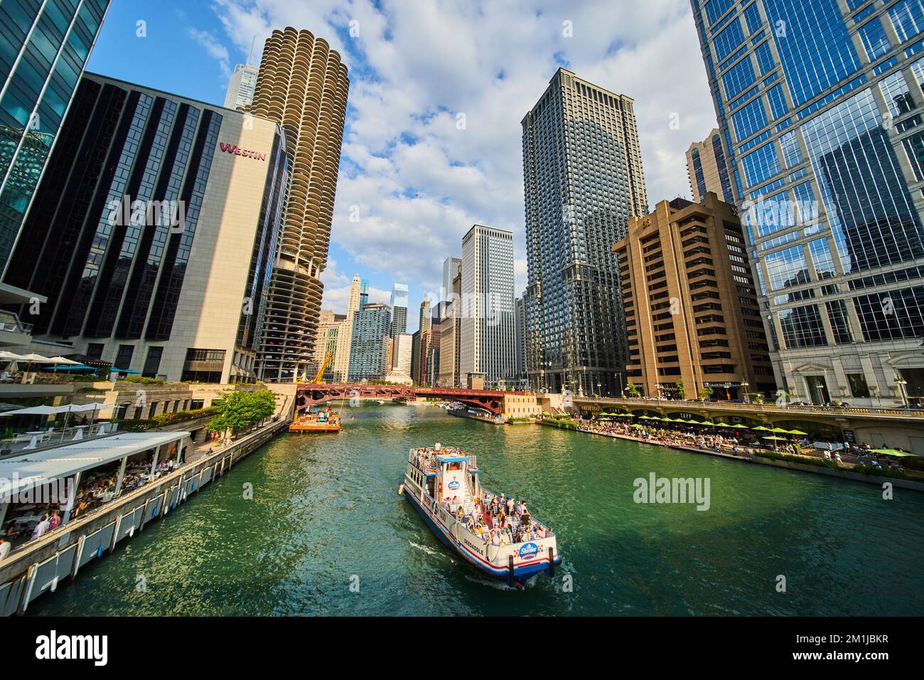 Tourist ship goes through Chicago ship canal lined with skyscrapers ...