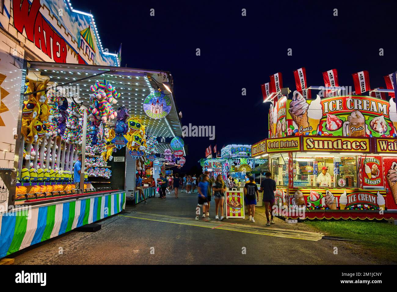 Nighttime at carnival county fair with vendors of games and food Stock ...
