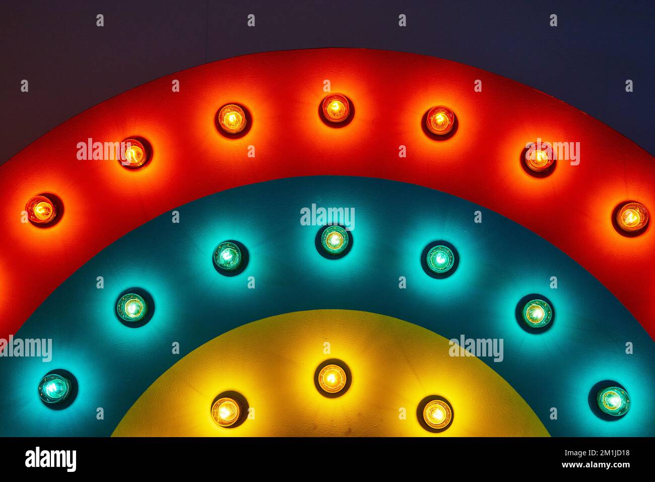 Red, blue, and yellow rings of light on rainbow wave art piece Stock ...