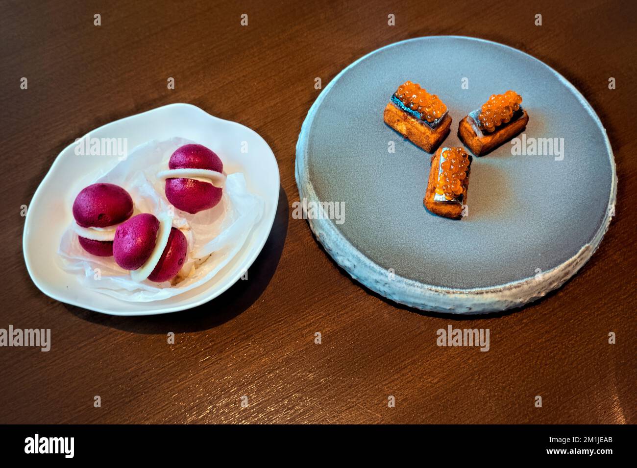 Beetroot macaron with goat cheese and panisse with trout roe served at ...