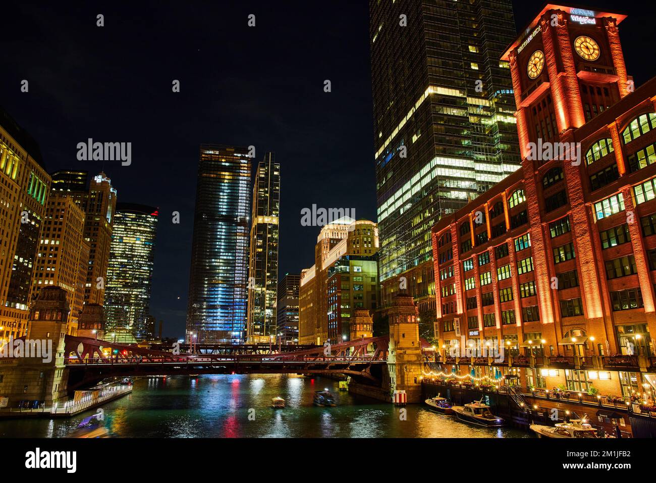 Buildings light up at night along Chicago ship canals with bridge Stock Photo - Alamy
