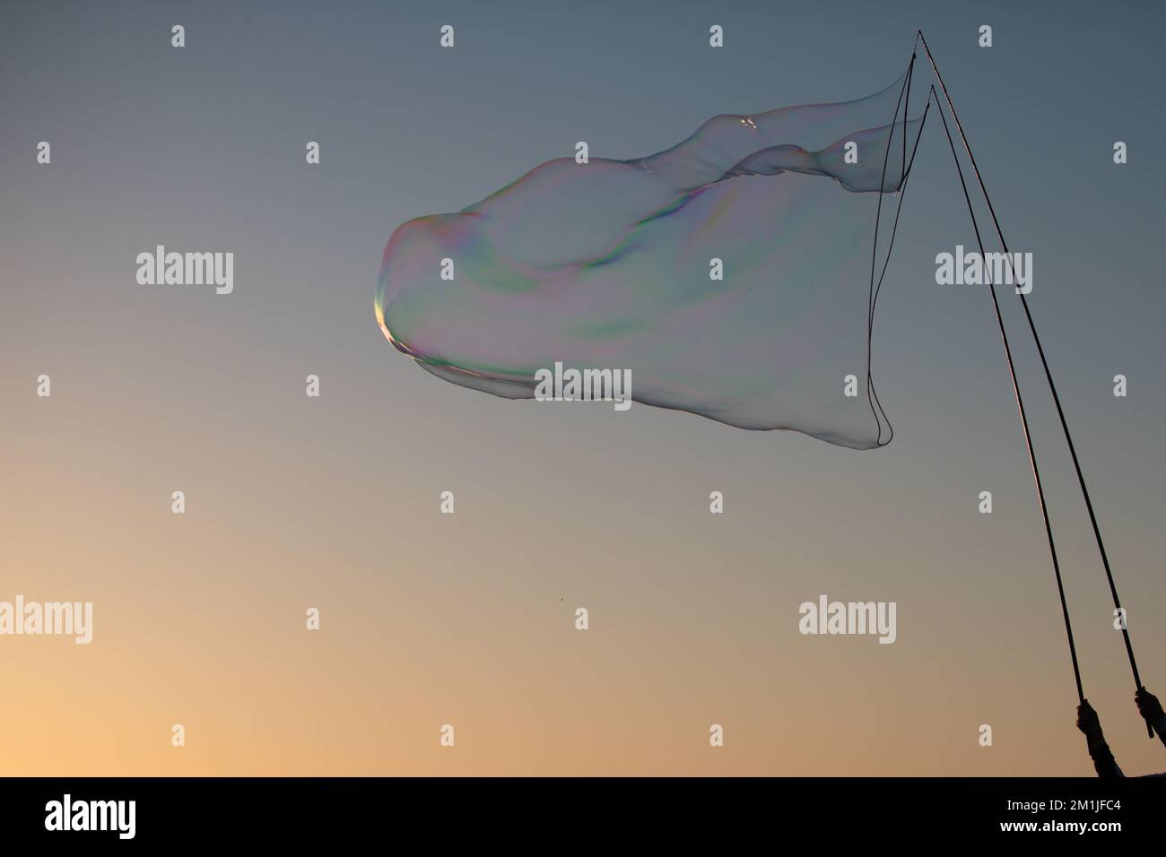 Giant colorful bubble. Big soap bubble on blue sky. Huge soap bubbles ...