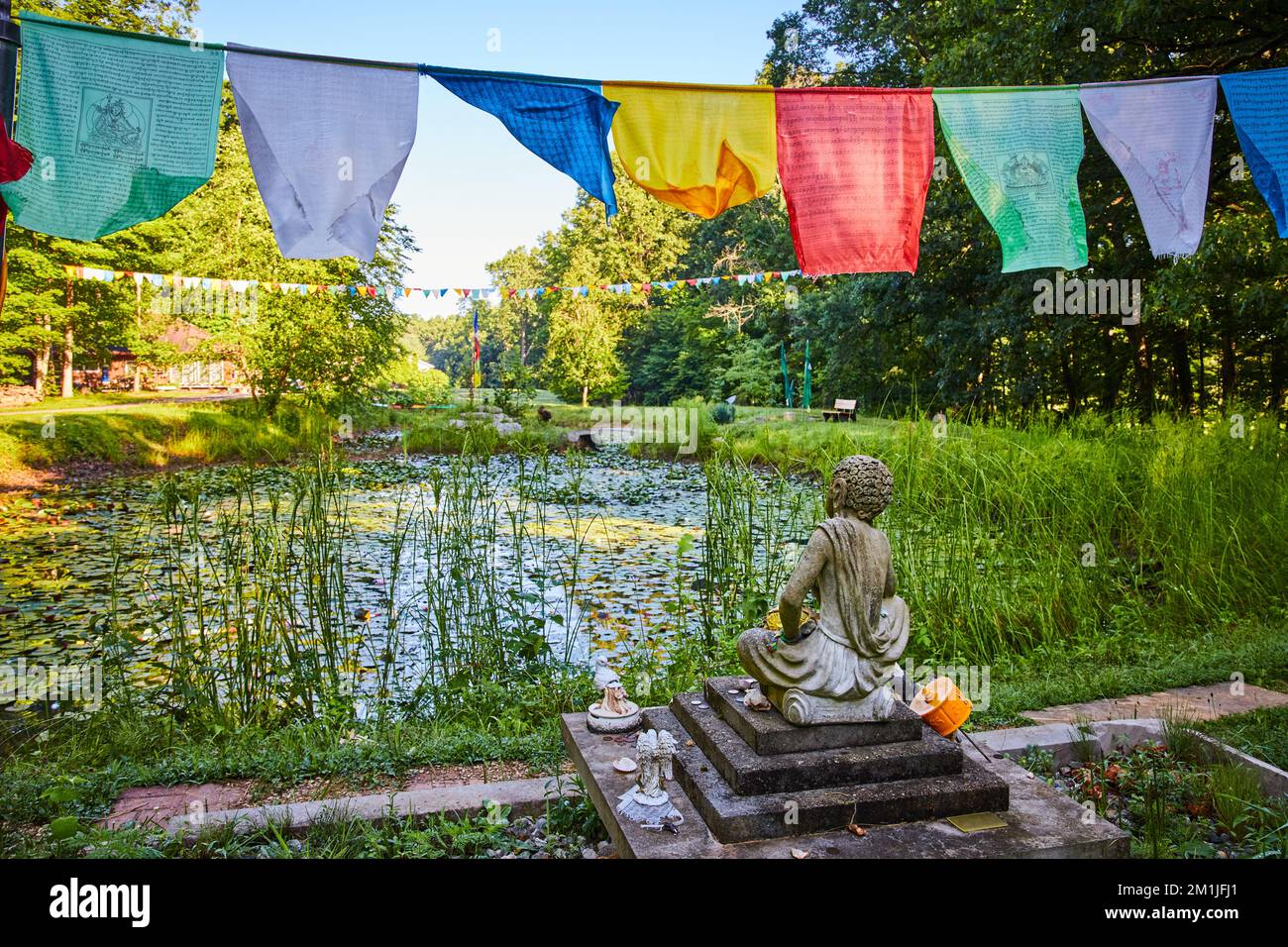 Lily pond from behind Tibetan Mongolian Buddhist statue with prayer ...