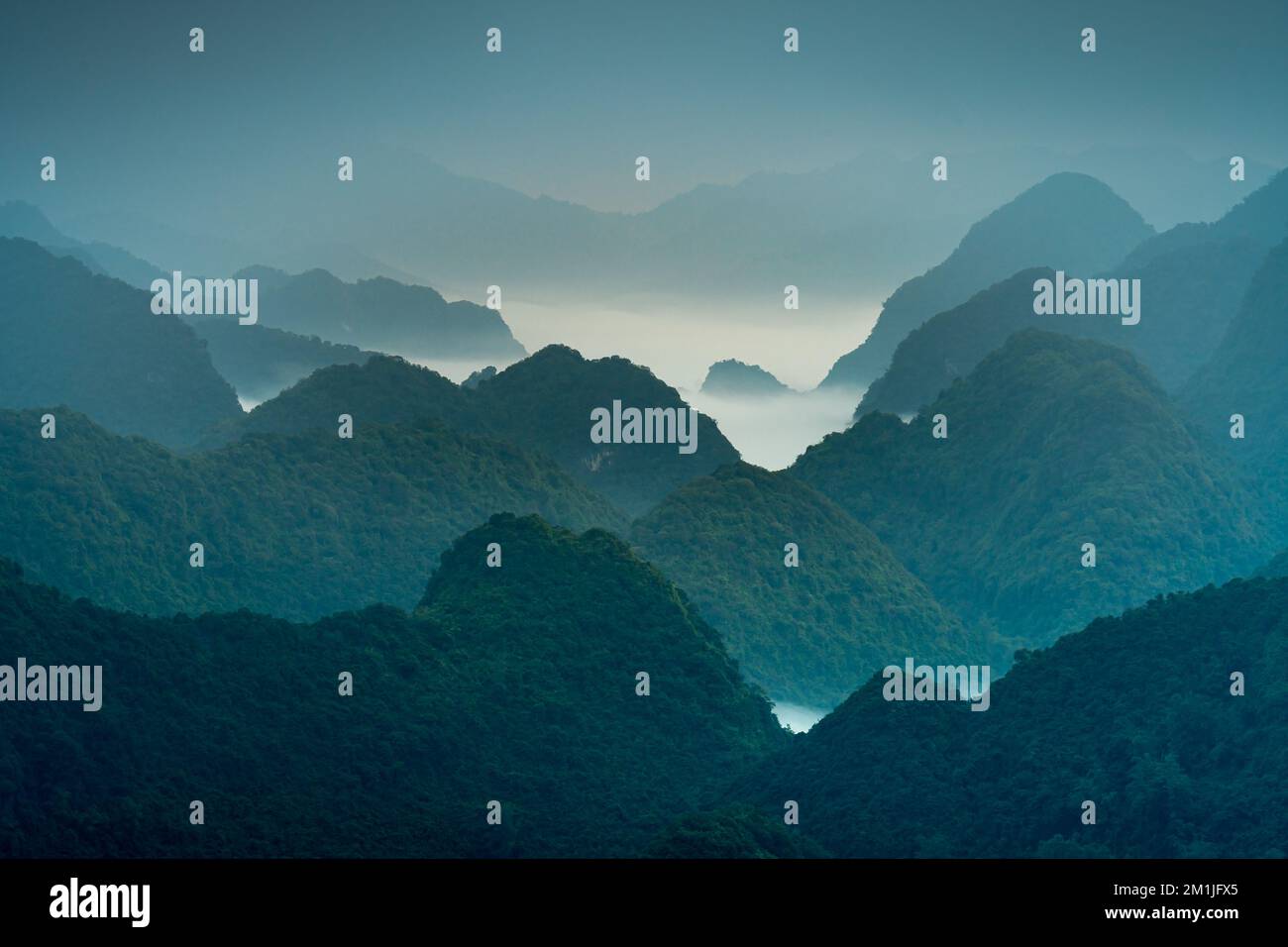 The fanciful scene of the mountains overlapping one another at dawn in ...