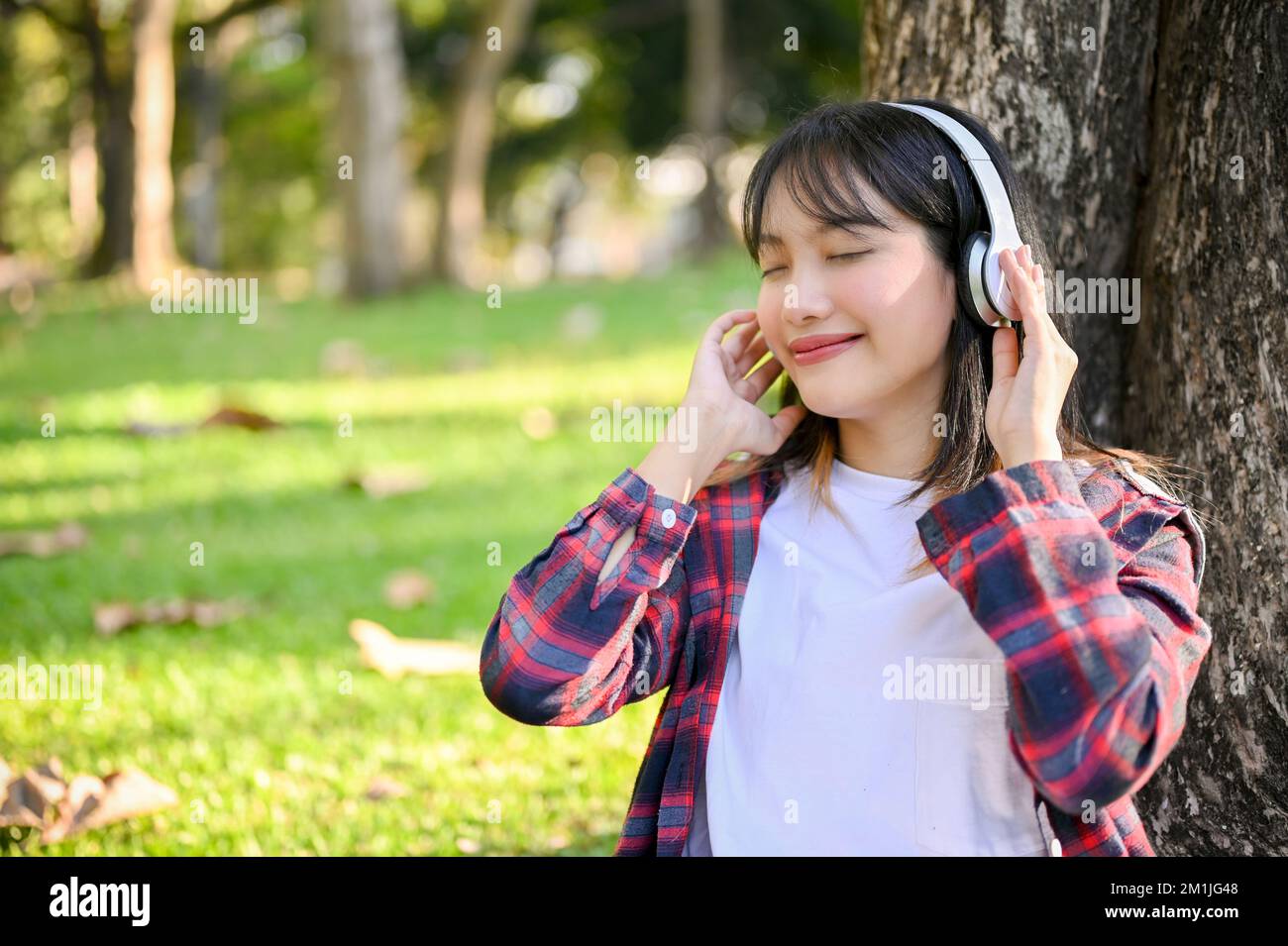 Charming and peaceful young Asian female college student enjoys ...