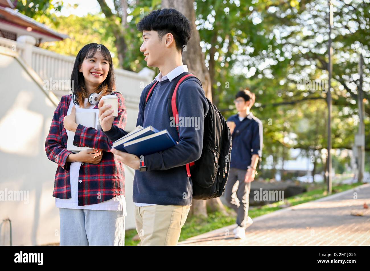 Two young Asian college students talking and sharing their ideas on ...