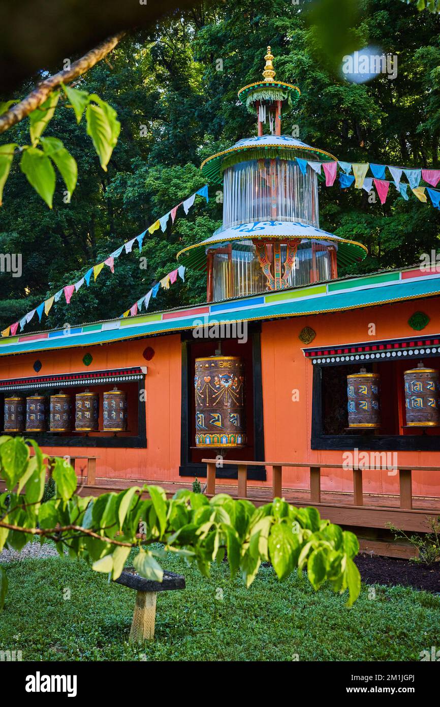 View through the leaves of large shrine with prayer wheels Stock Photo ...