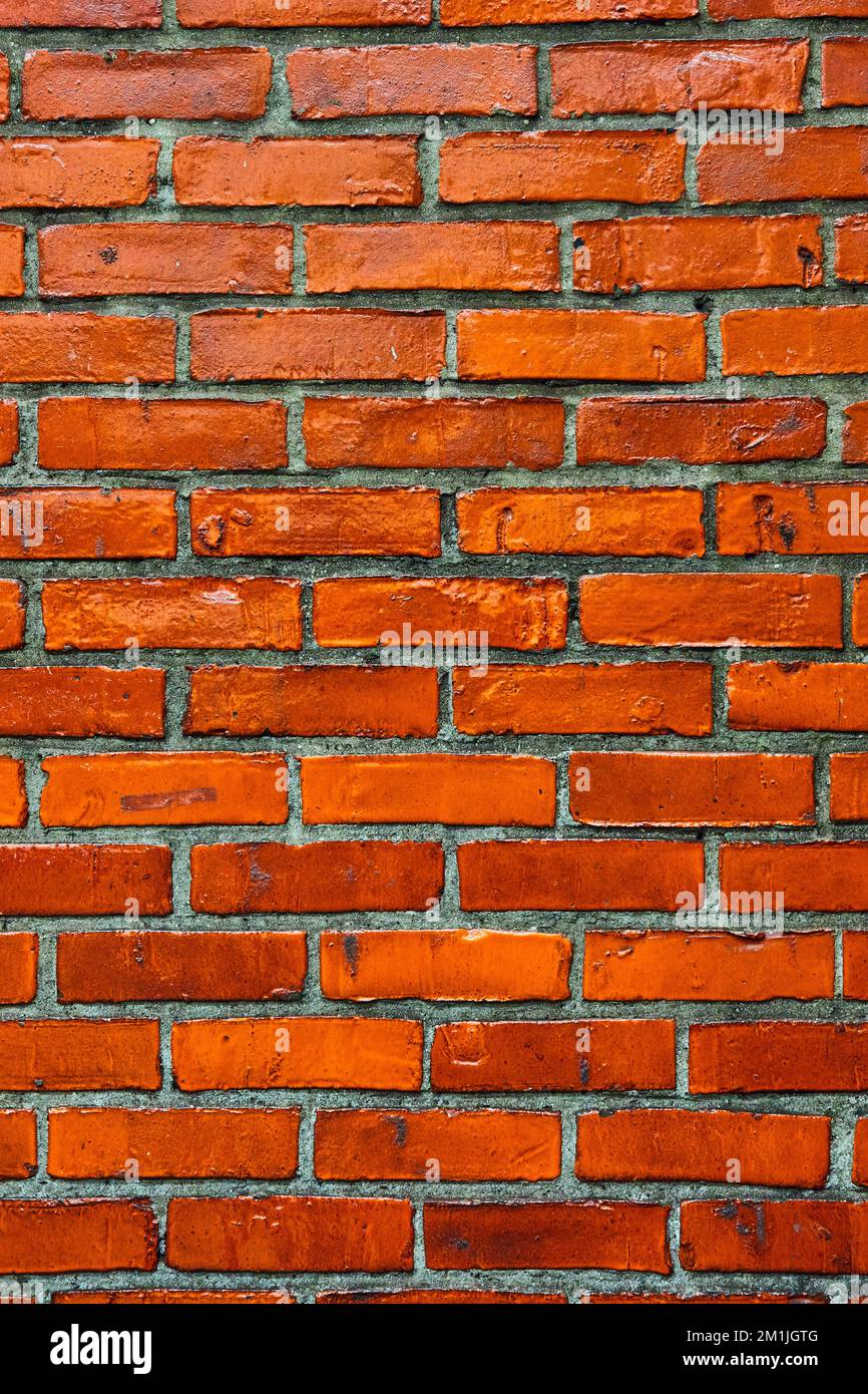 Vertical vibrant orange brick wall straight on texture with dark gray ...