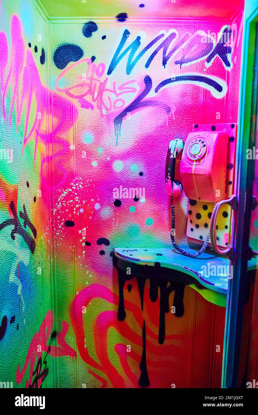 Phone booth fully painted in vibrant glowing colors Stock Photo - Alamy