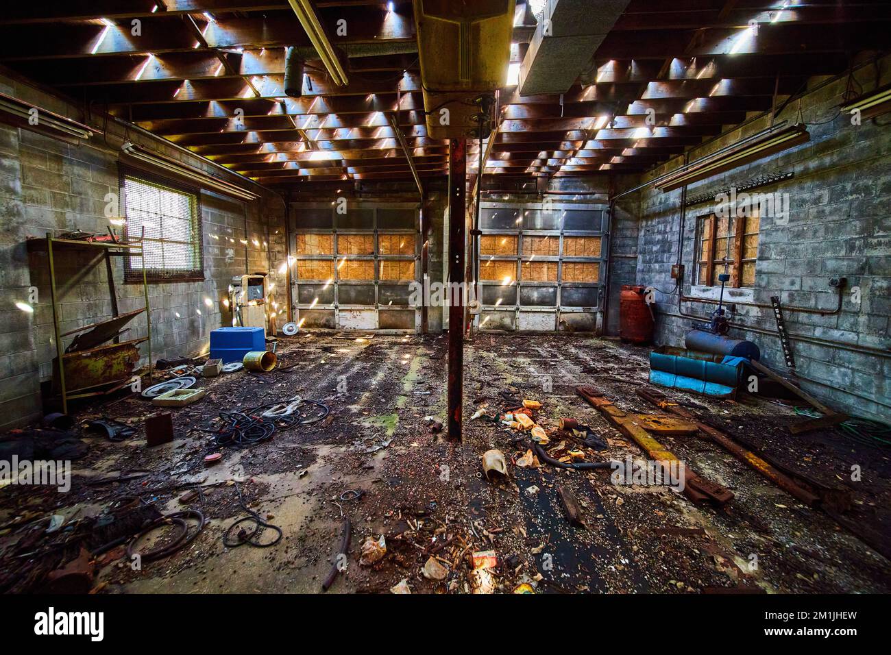 Interior of abandoned double garage mechanic shop with dirty floor and ...