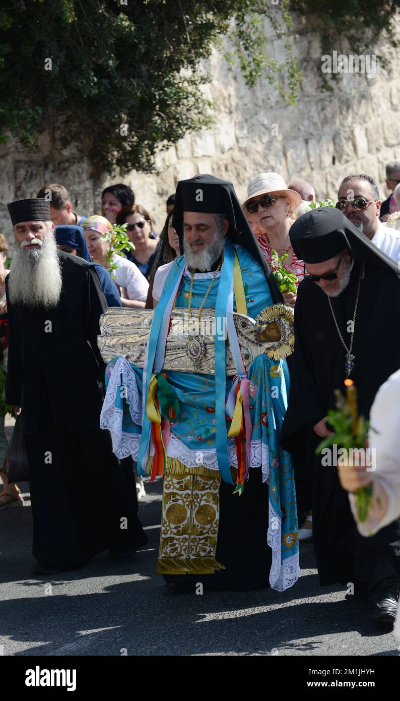 A Greek Orthodox priest carrying a silver icon of the Virgin Mary ...