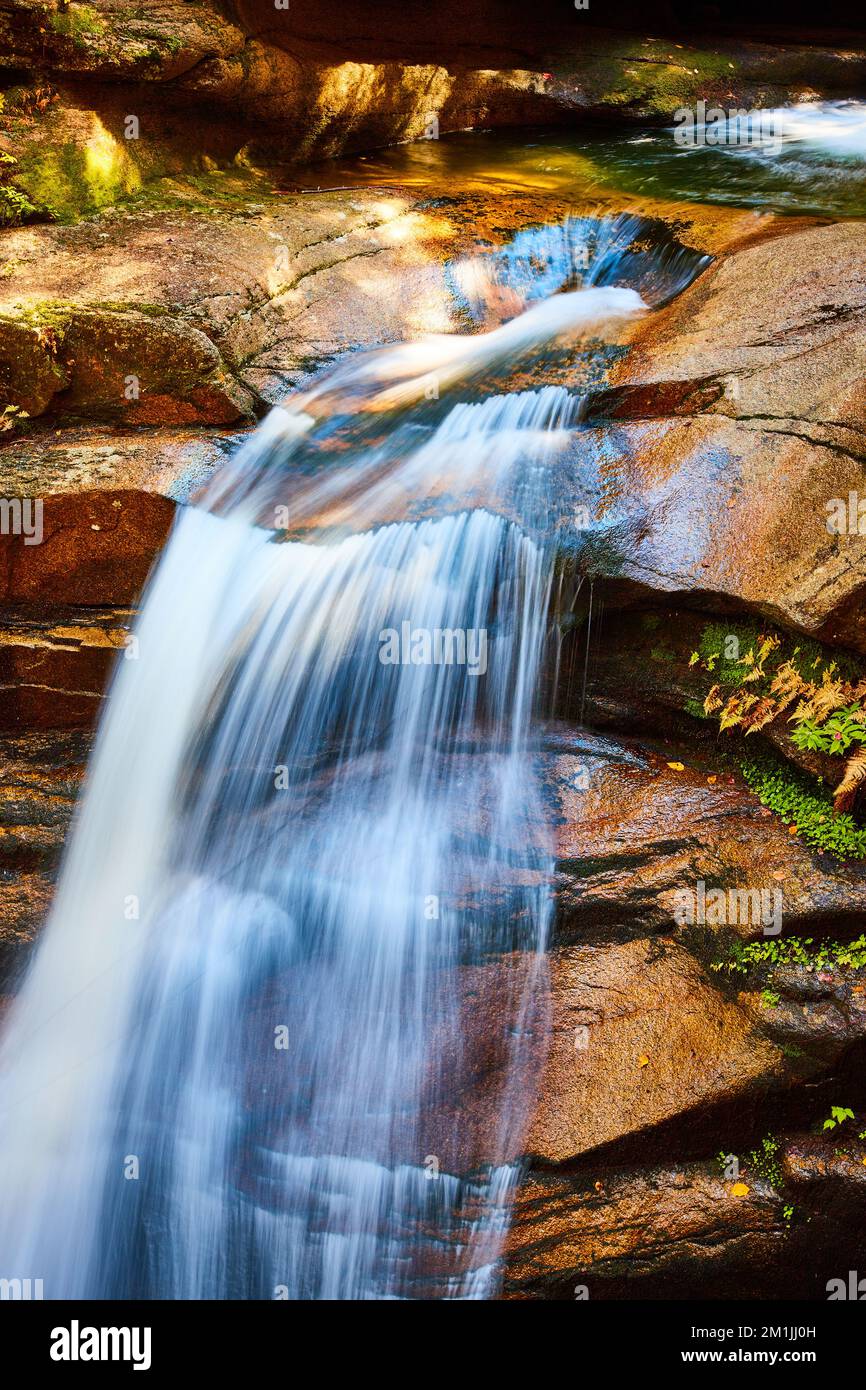 Stunning edge of waterfall pouring over rocky edge with moss and motion ...