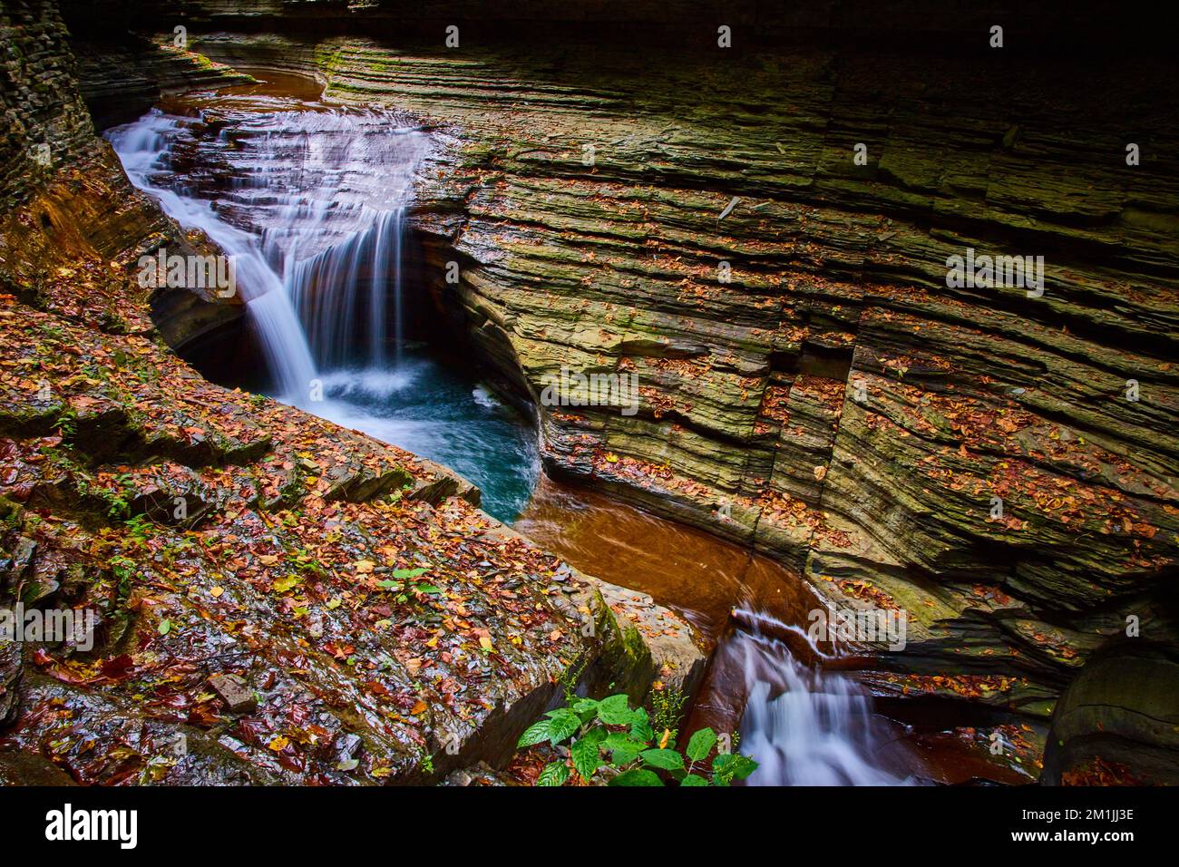 Stunning waterfall through terraced rocks covered in fall foliage Stock ...