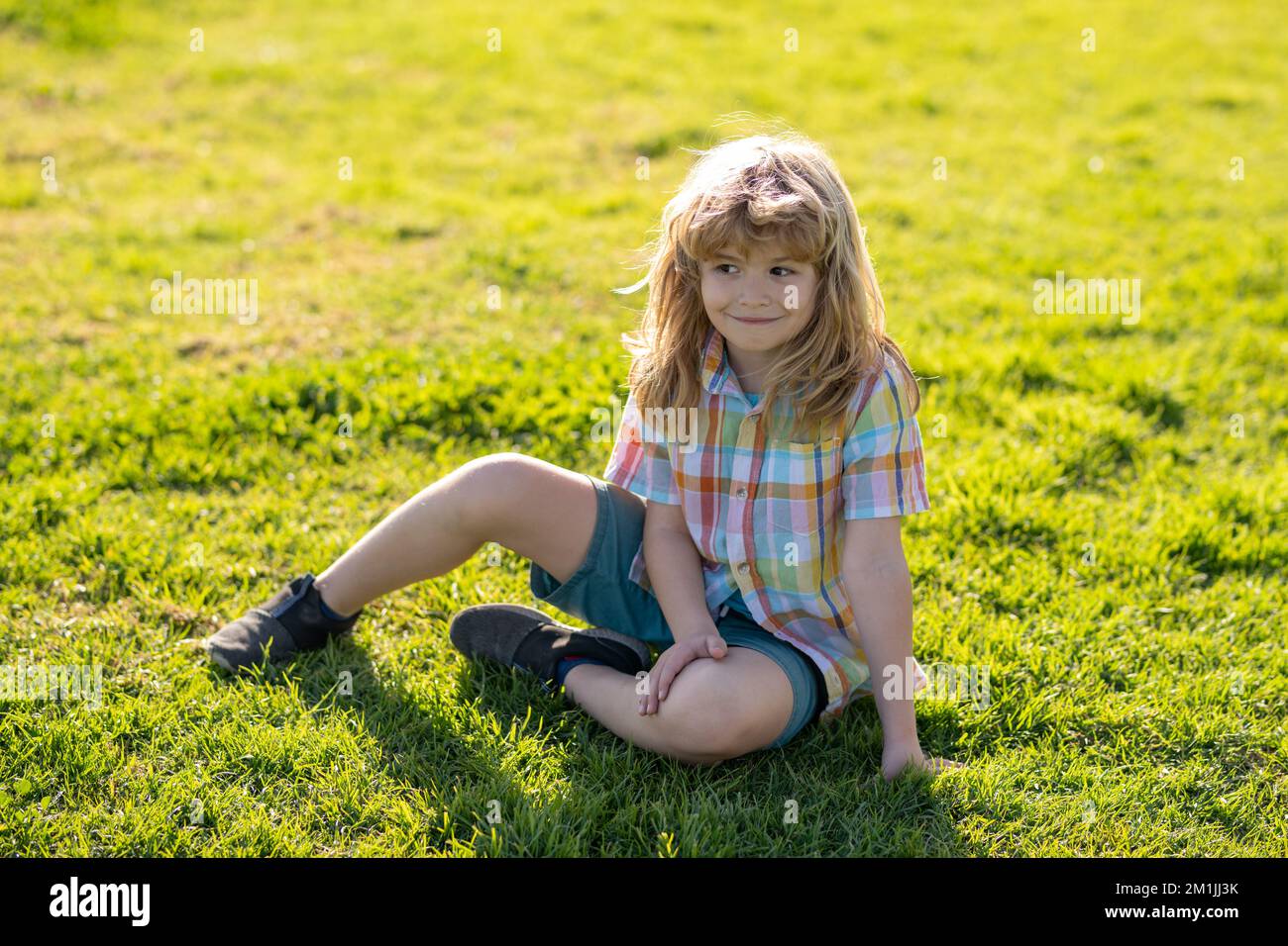Summer kids outdoor portrait. Happy child enjoying on grass field and ...