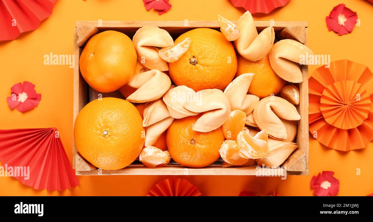 Box with tasty fortune cookies, tangerines and Chinese symbols on ...