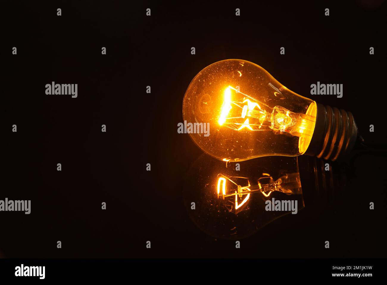 Glowing light bulb on black background Stock Photo - Alamy
