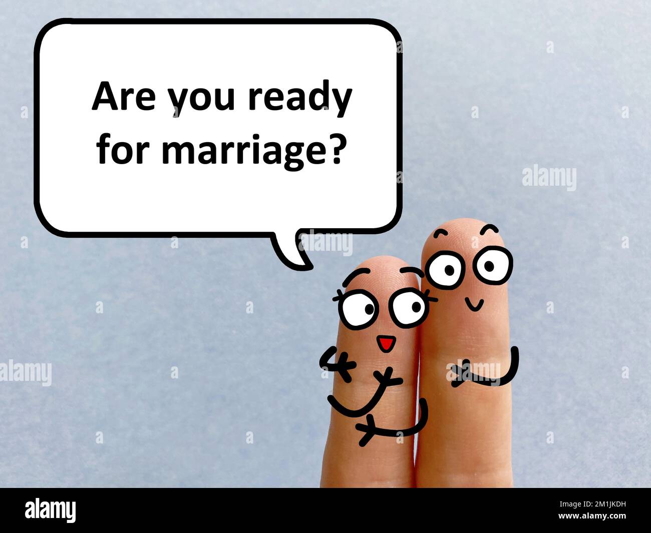 Two fingers are decorated as two person. They are getting married. One ...