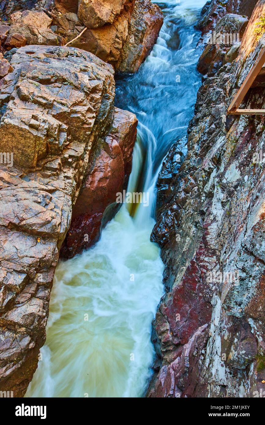 Deep stone gorge with river rapids and intense waterfall flowing ...