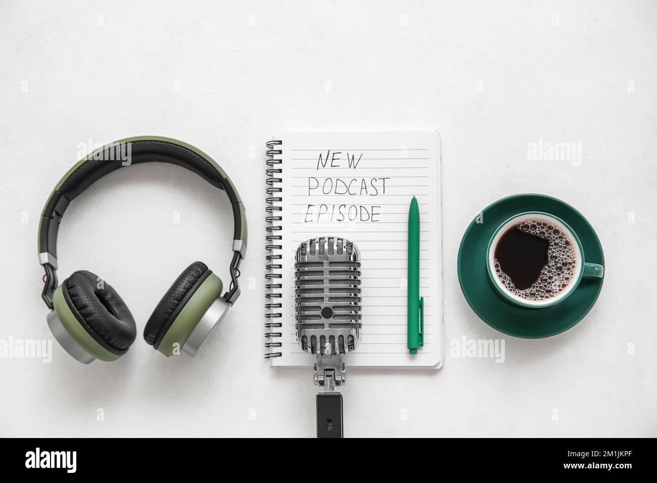 Notebook with text NEW PODCAST EPISODE, microphone, coffee cup and ...