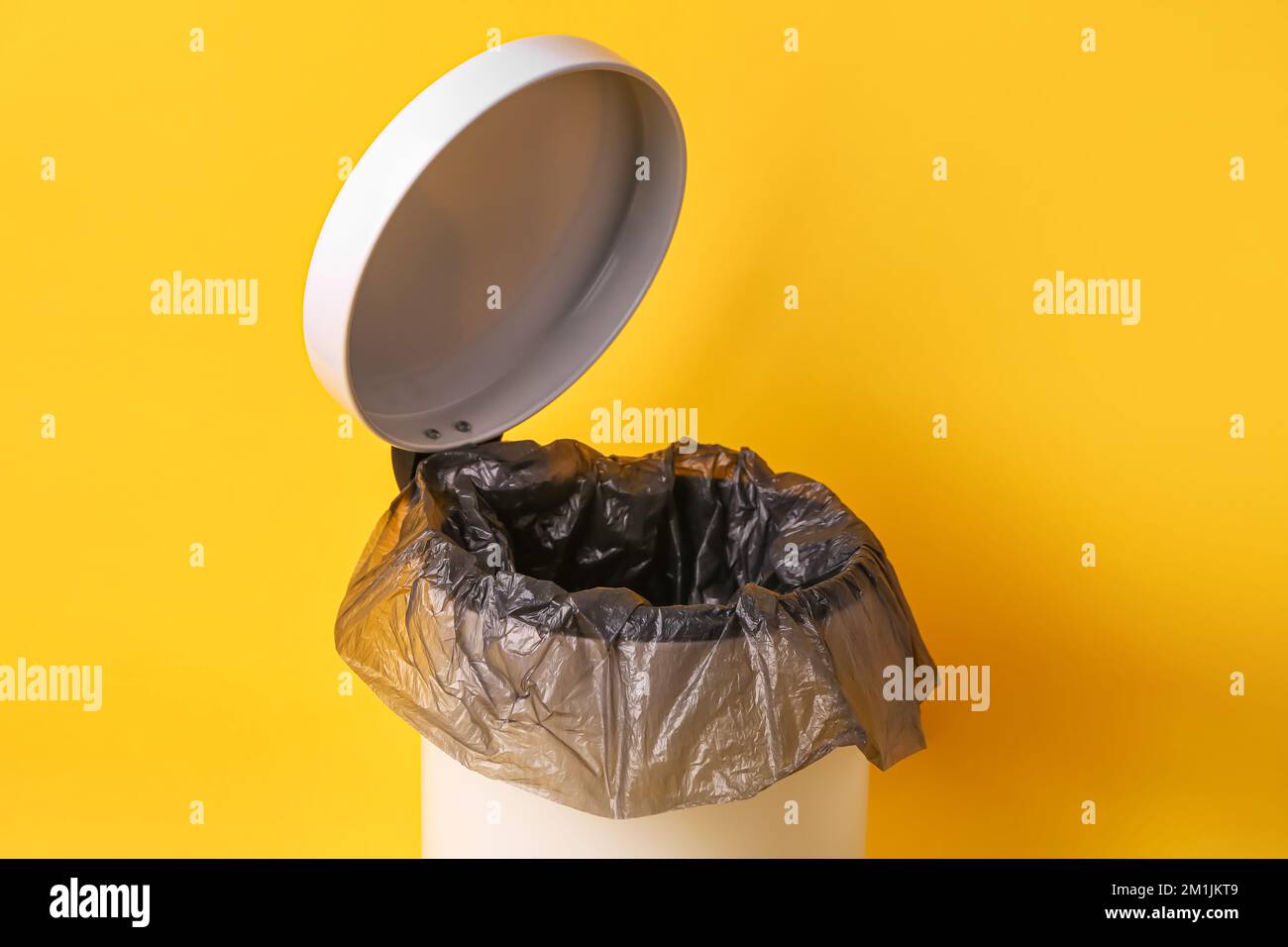 Open rubbish bin on yellow background Stock Photo - Alamy