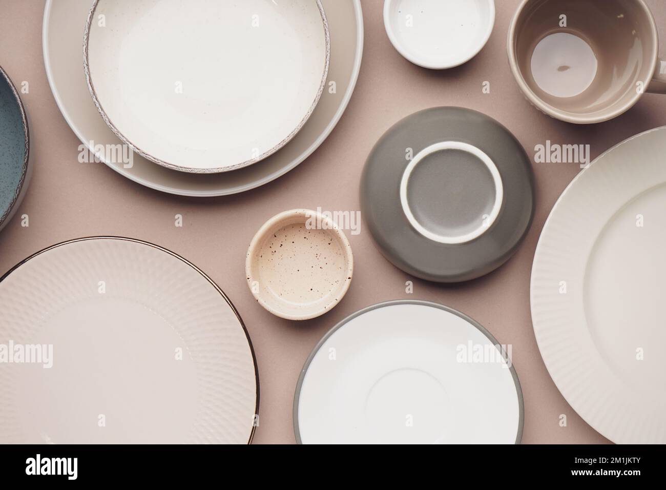 Different clean dishware on beige background Stock Photo - Alamy