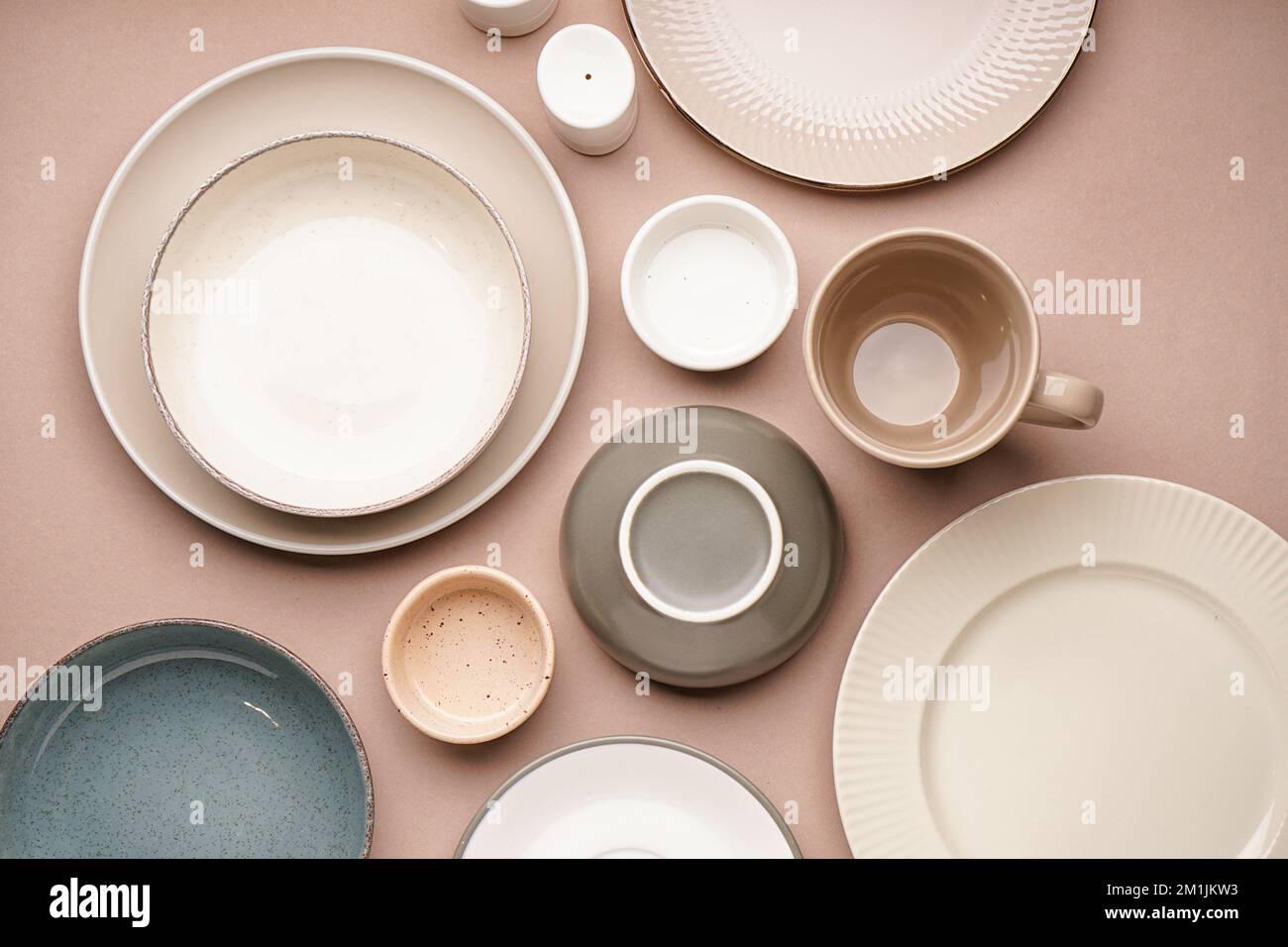 Different clean dishware on beige background Stock Photo - Alamy