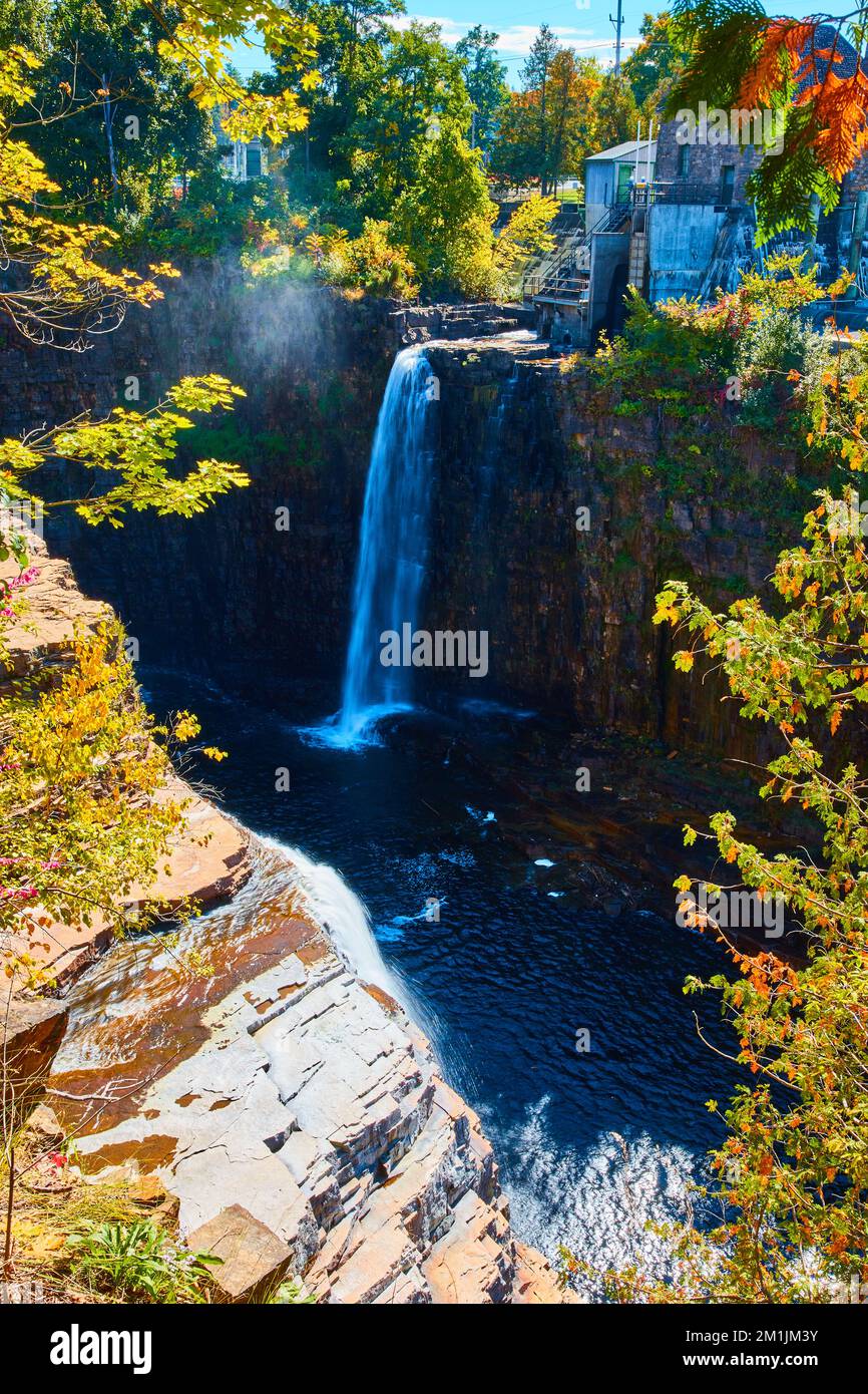 View through trees of waterfall going over cliffs from Hydroelectric ...