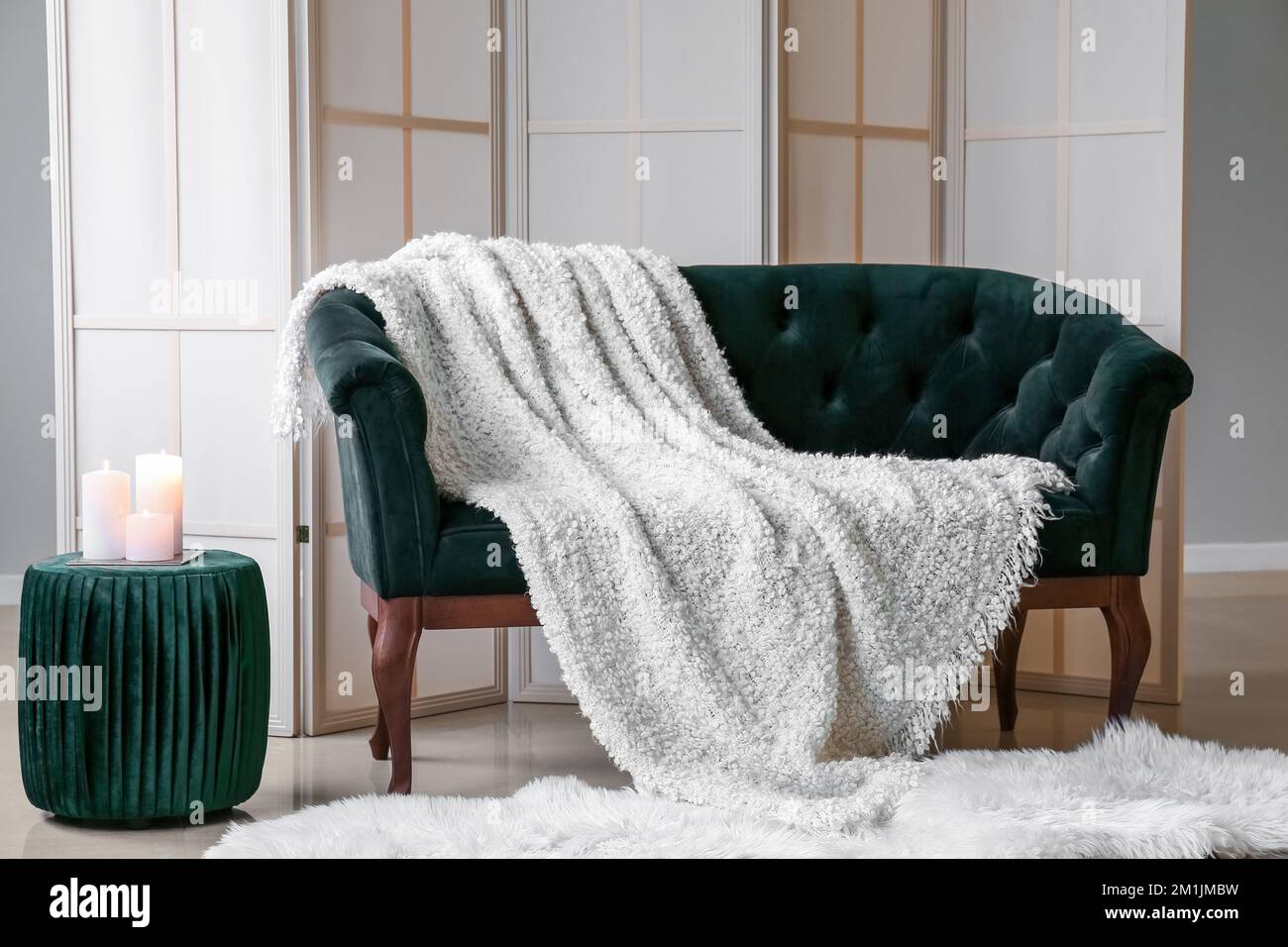 Interior of stylish living room with sofa, pouf and folding screen ...