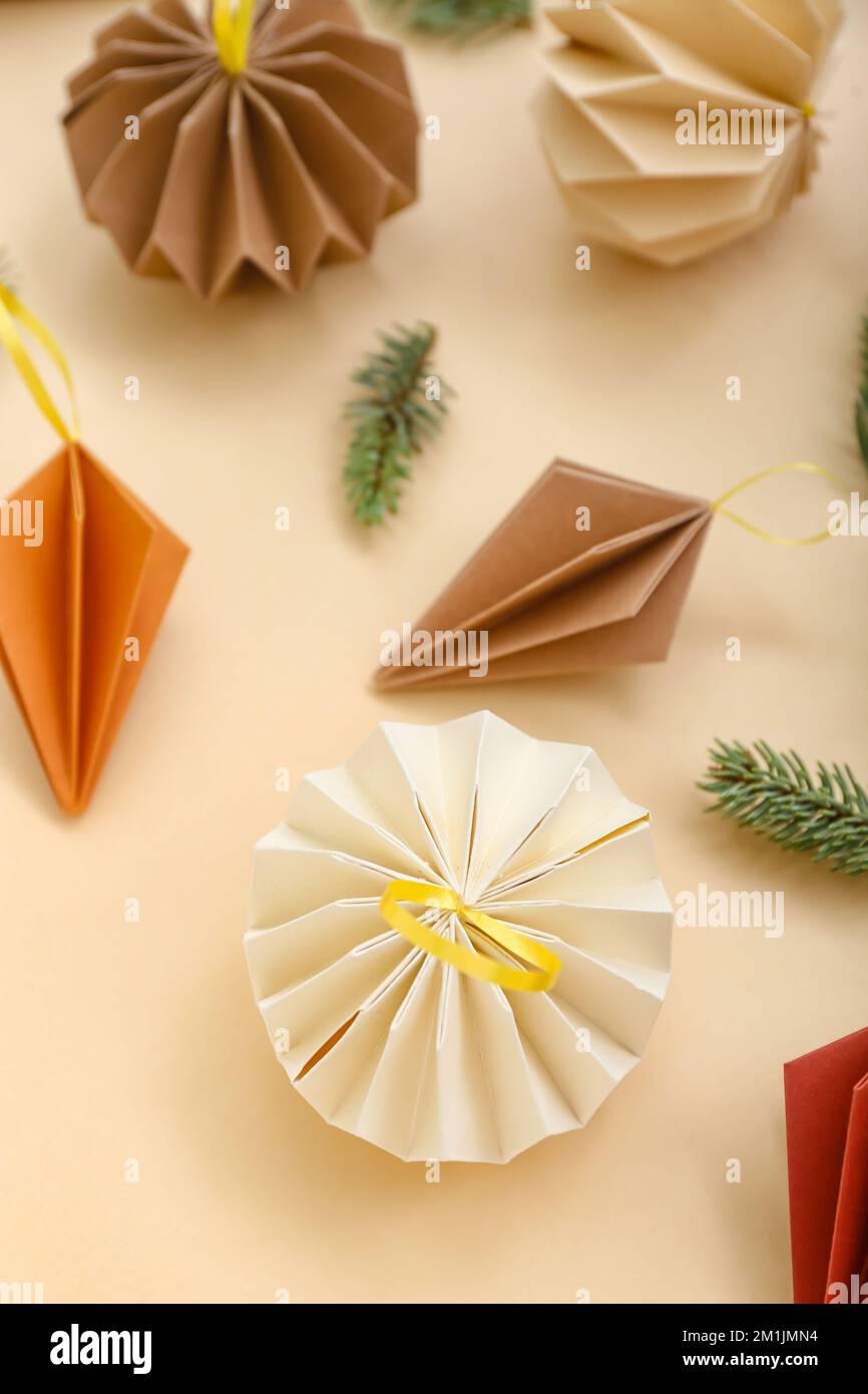 Paper Christmas balls with fir branches on beige background, closeup ...