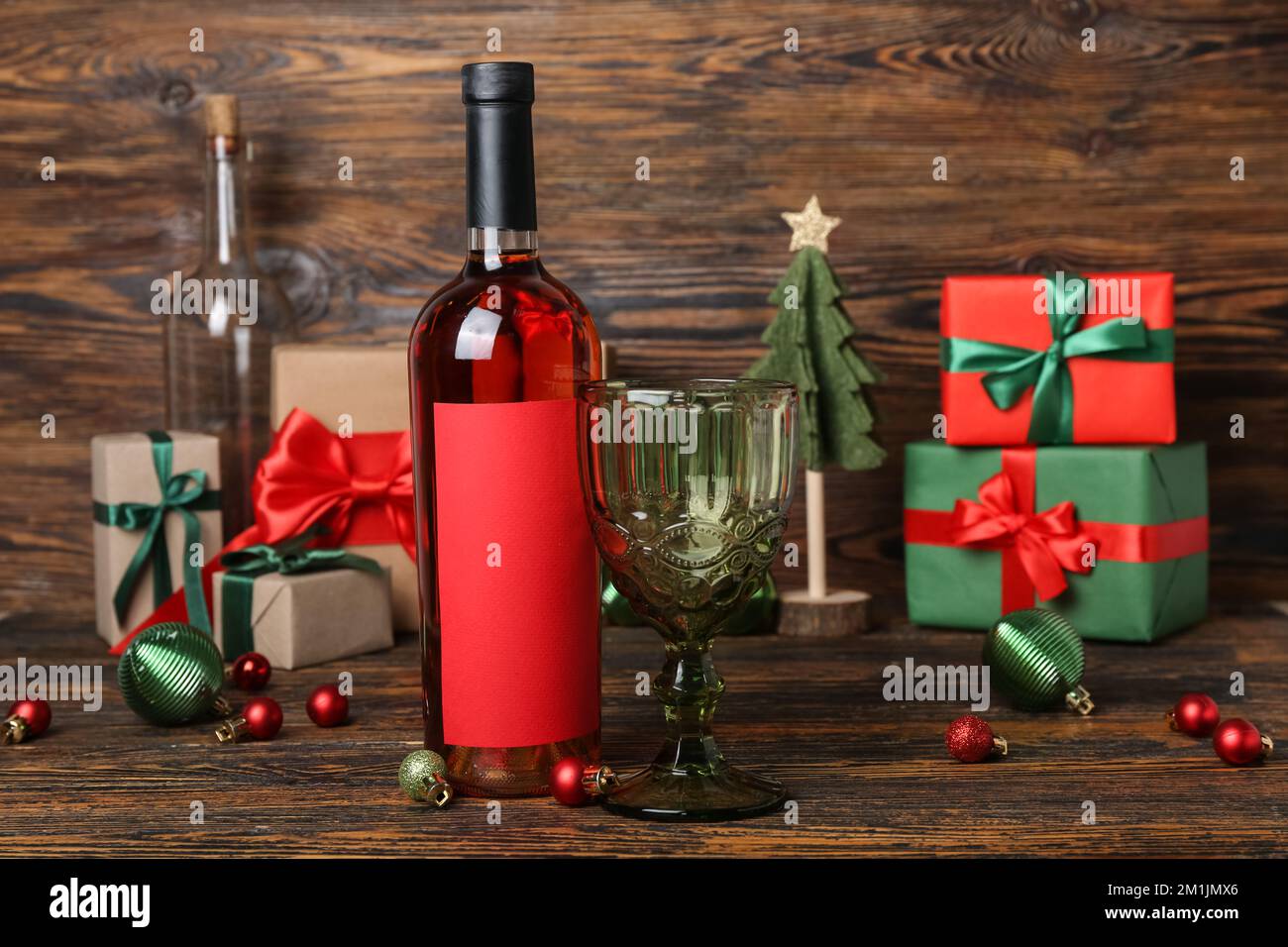 Bottle of wine with glass and Christmas balls on dark wooden background ...