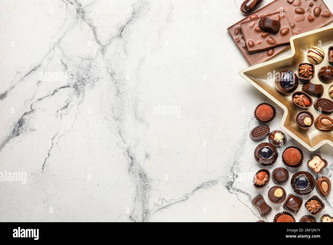 Candies and chocolate bar on white marble background Stock Photo - Alamy