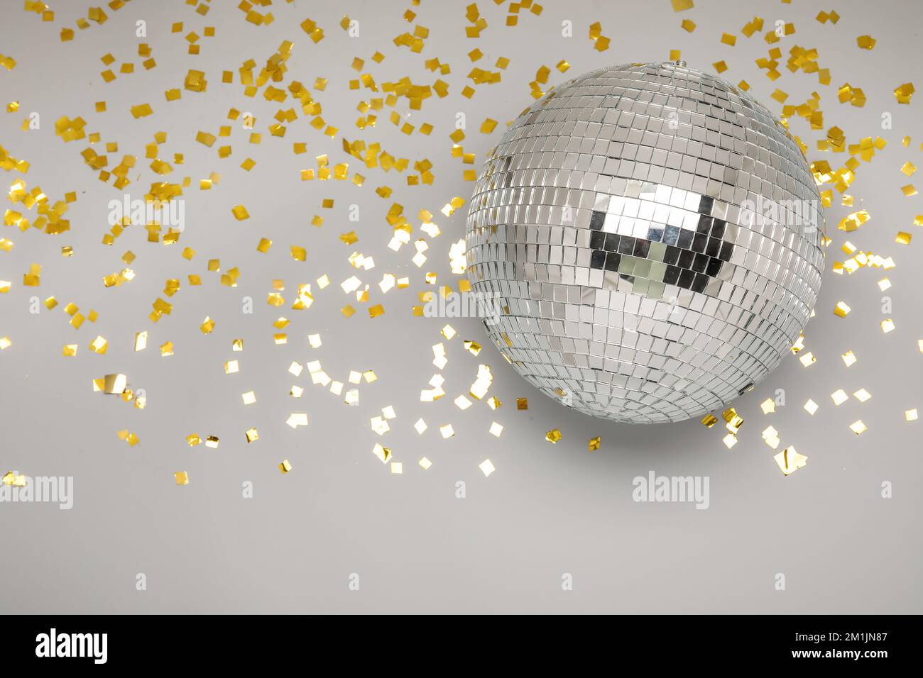 Disco ball with confetti on grey background Stock Photo - Alamy