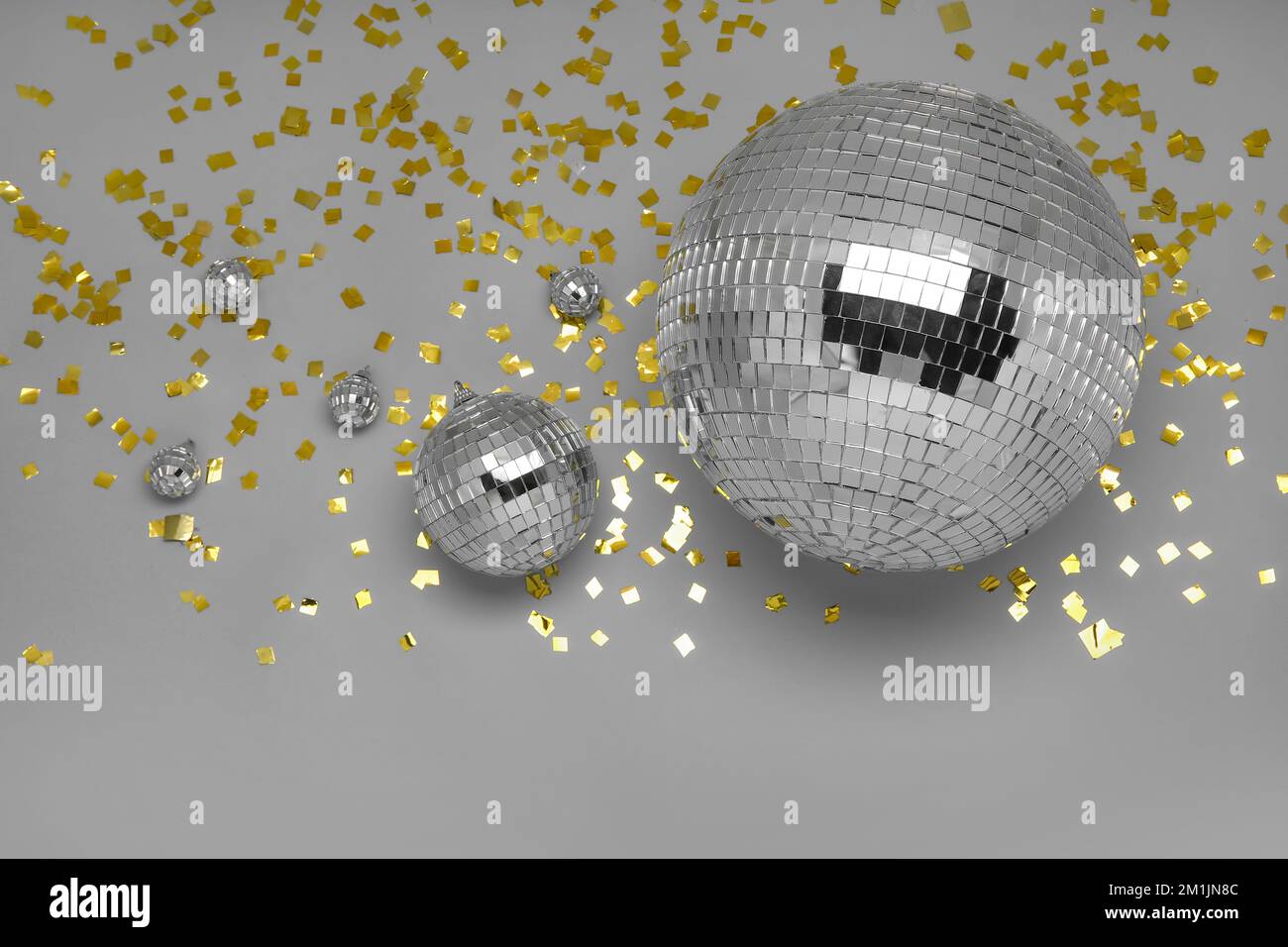 Disco balls with confetti on grey background Stock Photo - Alamy